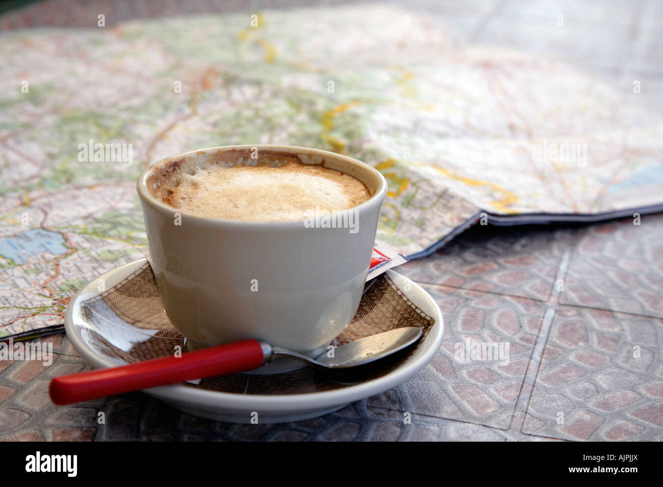 Close up of Italian cappuccino and road map of Italy in the background ...