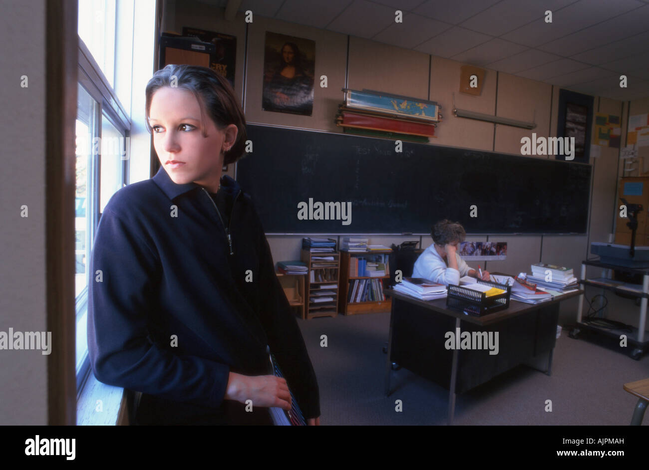 High school student standing by window in classroom Stock Photo - Alamy