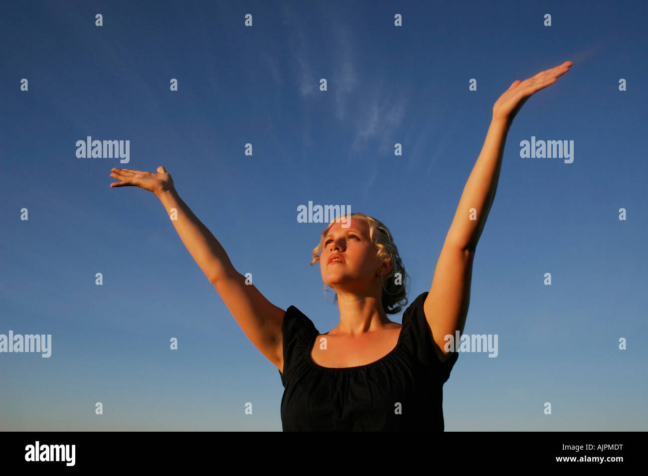 Woman with her arms raised Stock Photo - Alamy