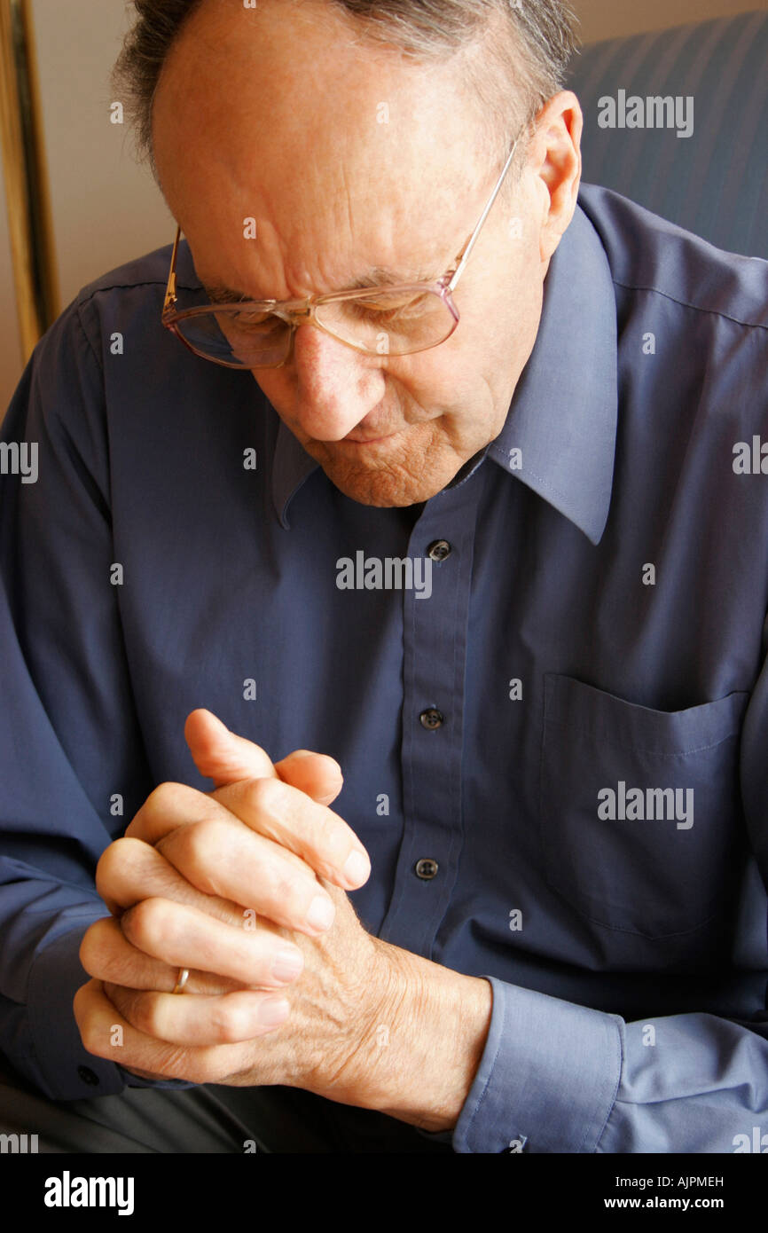 Elderly man praying Stock Photo - Alamy