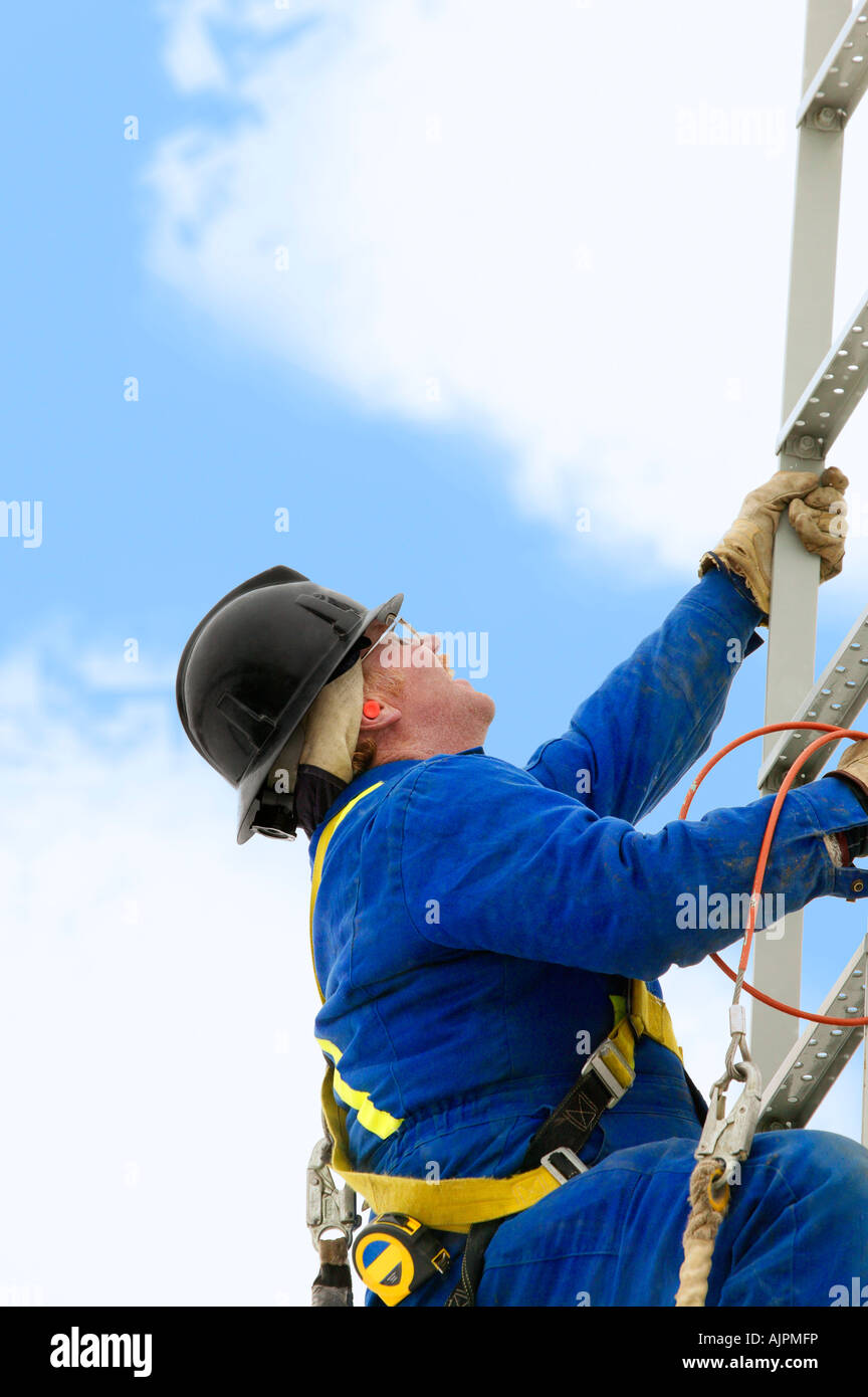 Industry worker climbing a ladder Stock Photo - Alamy