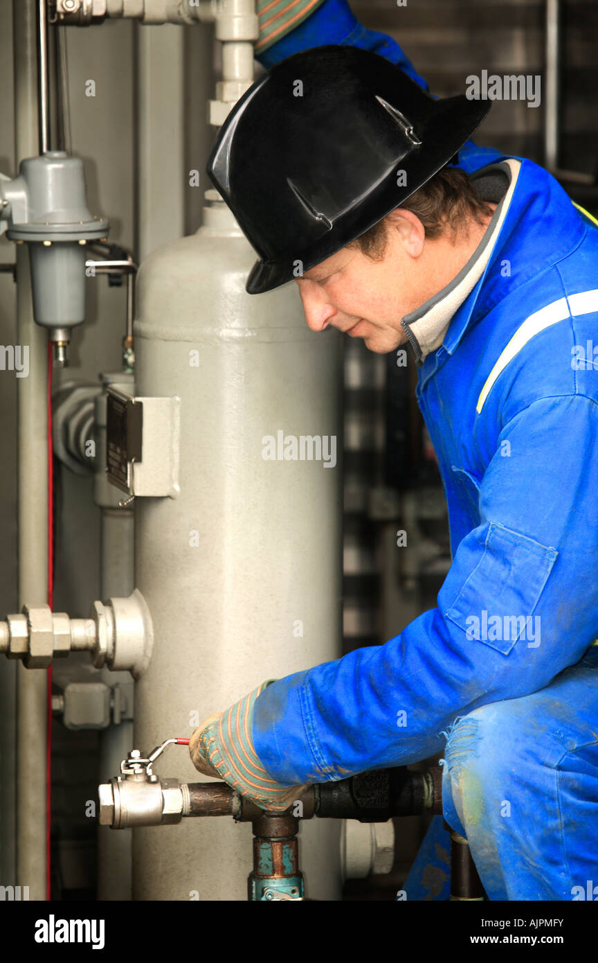 Industrial worker adjusting equipment Stock Photo - Alamy
