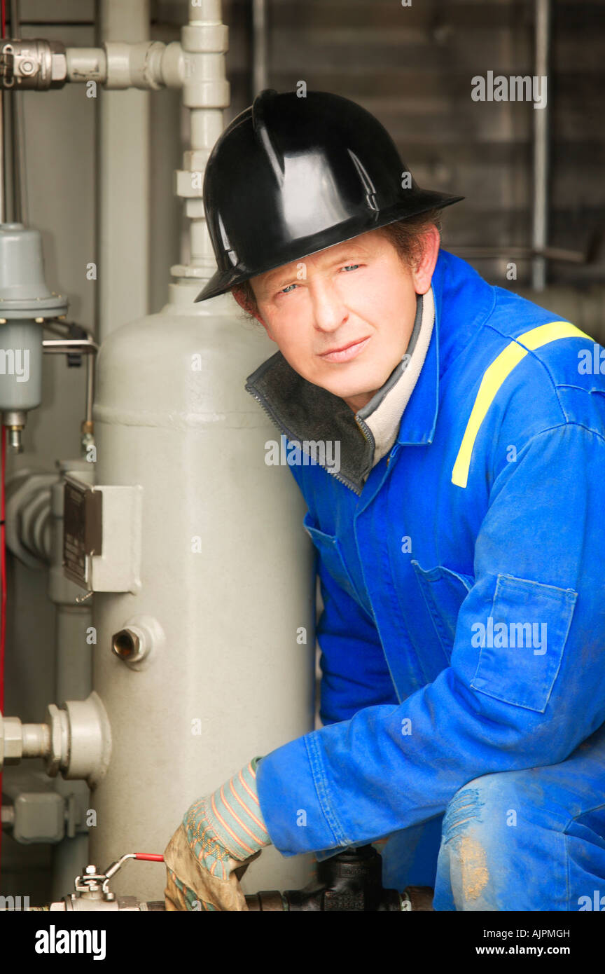 Industrial worker adjusting equipment Stock Photo - Alamy
