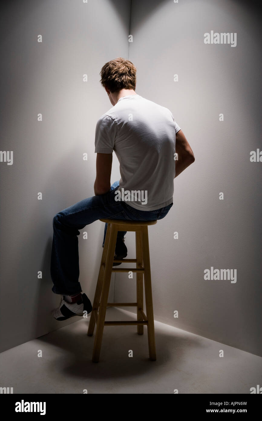 Young man sitting on a stool Stock Photo - Alamy