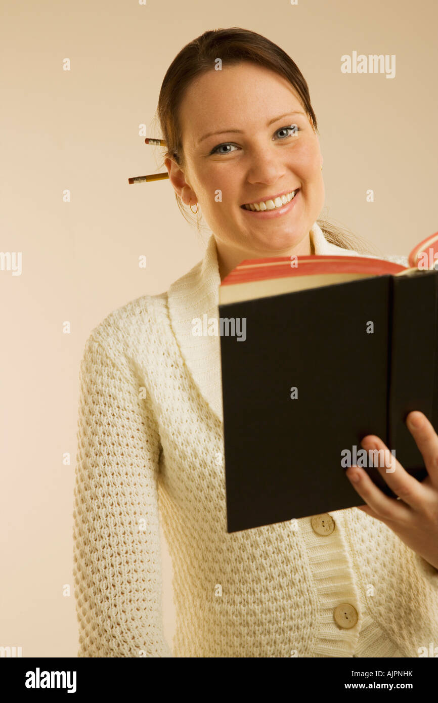 A woman smiling and reading book Stock Photo - Alamy