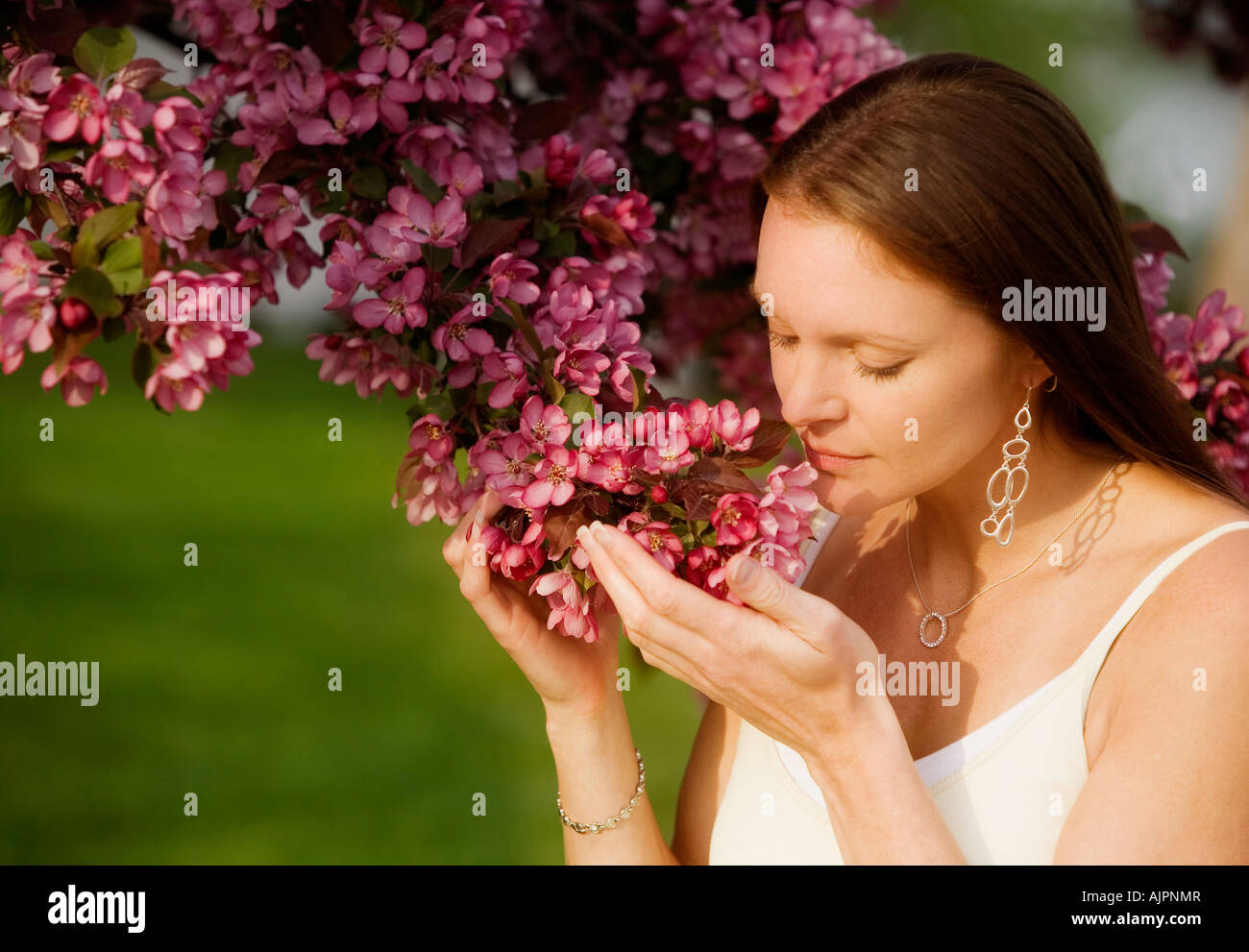 A young woman smelling flowers Stock Photo - Alamy
