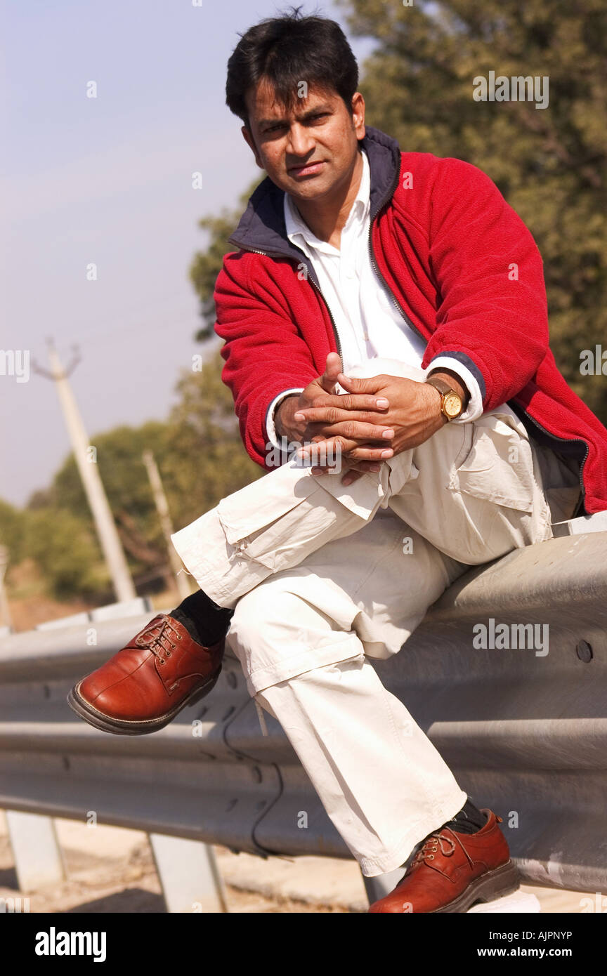 Man sitting on a railing Stock Photo - Alamy