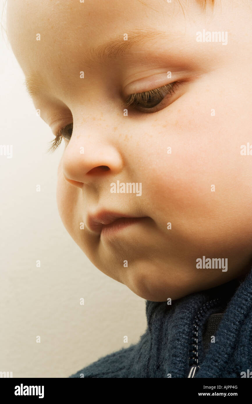 Young boy looking down Stock Photo - Alamy