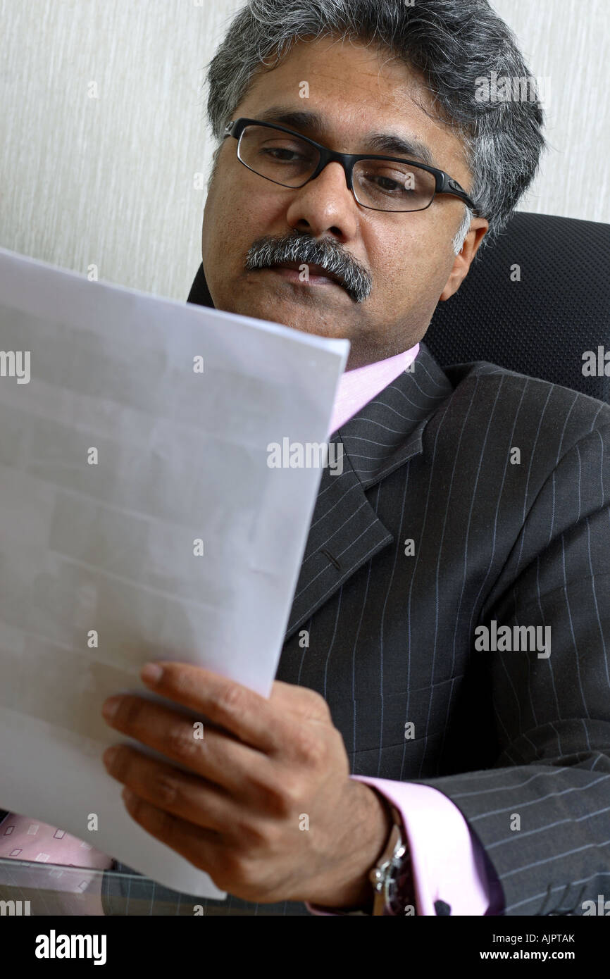Businessman reading a paper Stock Photo - Alamy