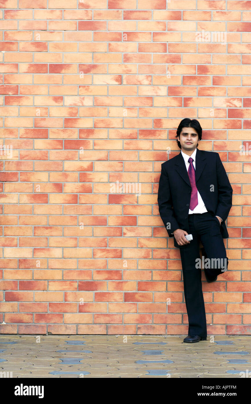 Portrait of a man leaning on a wall Stock Photo - Alamy