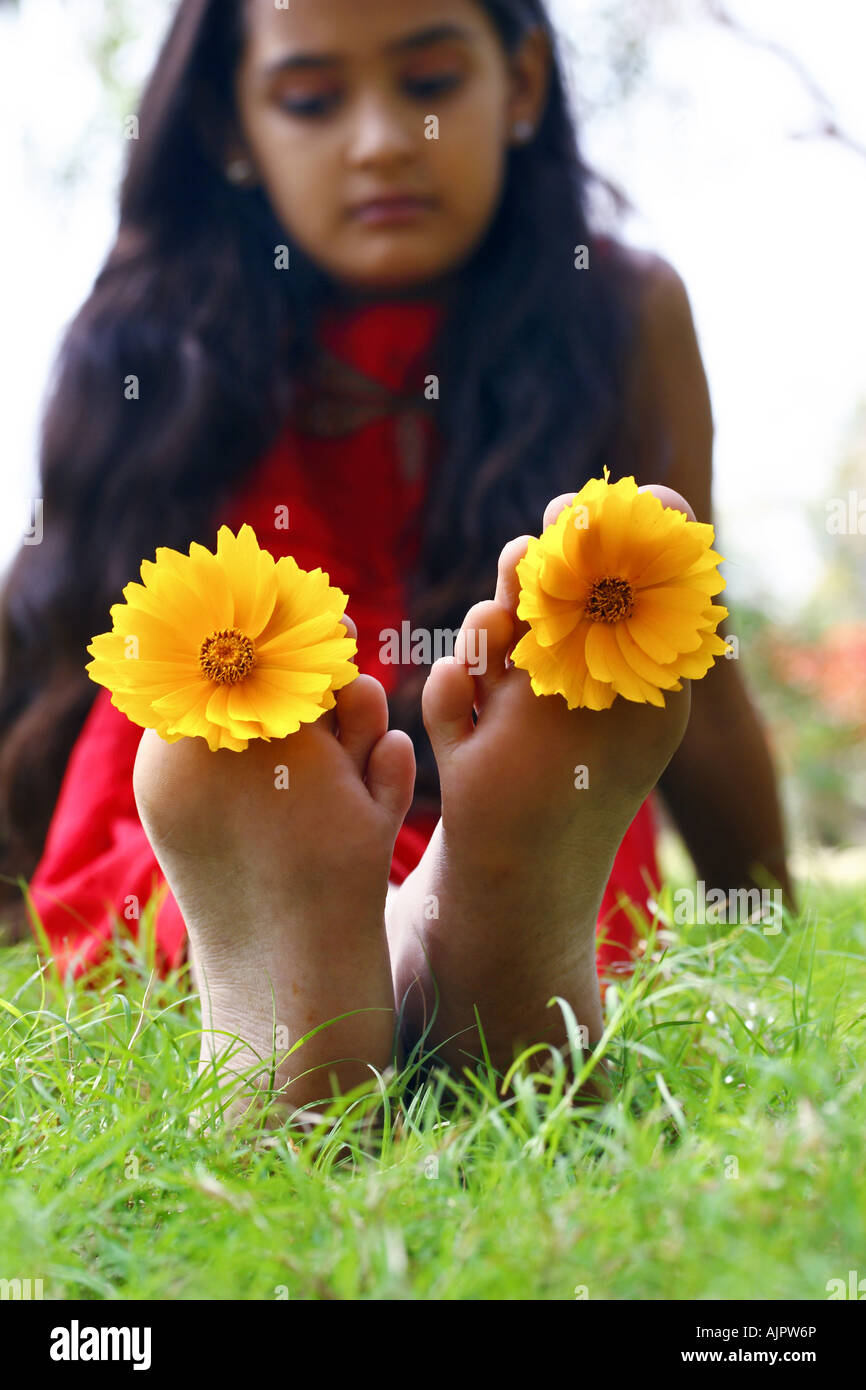 Portrait of a young girl with flowers placed between her toes Stock ...