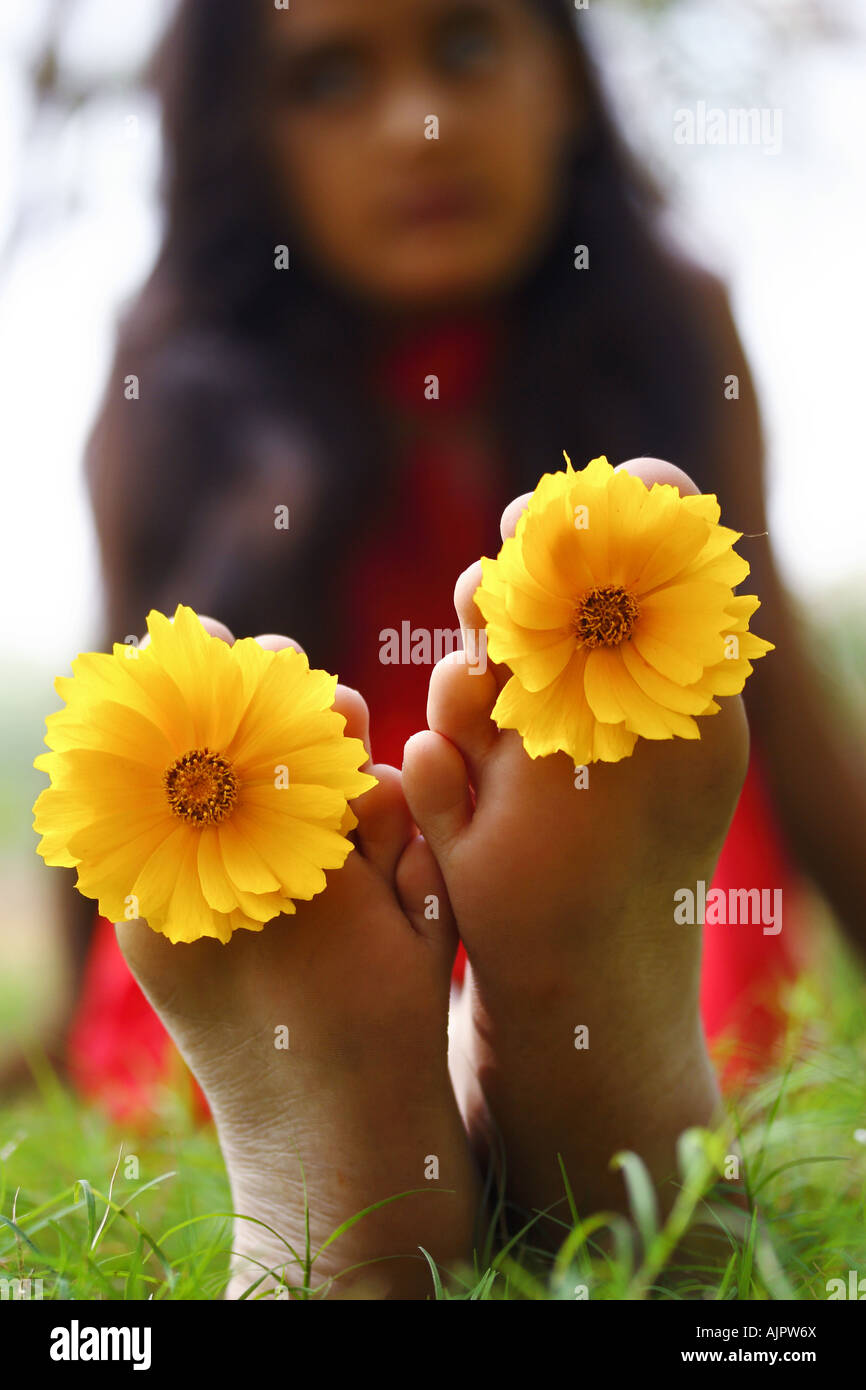 Portrait of a young girl with flowers placed between her toes Stock ...