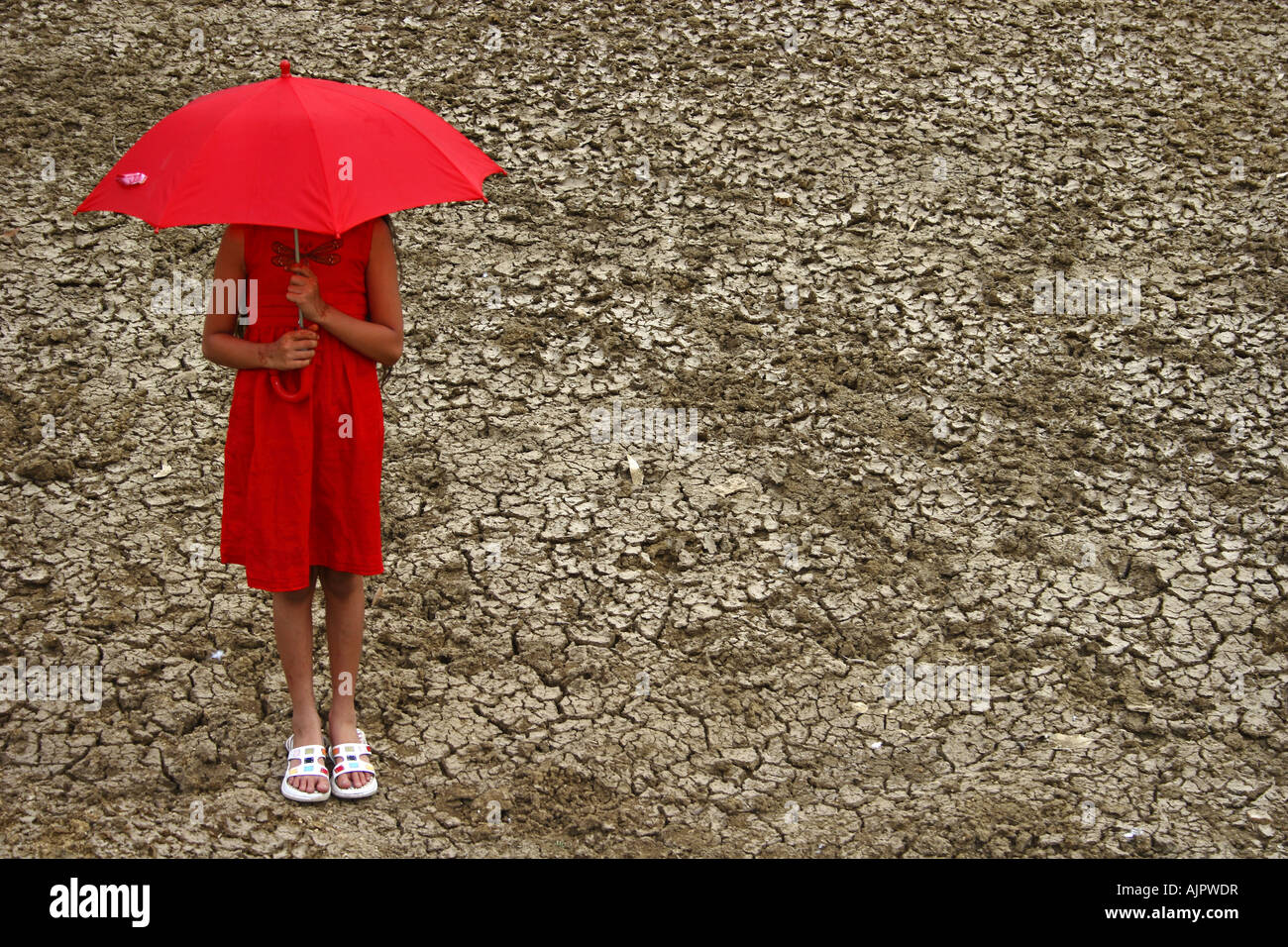 A girl with an umbrella on a dry land Stock Photo - Alamy