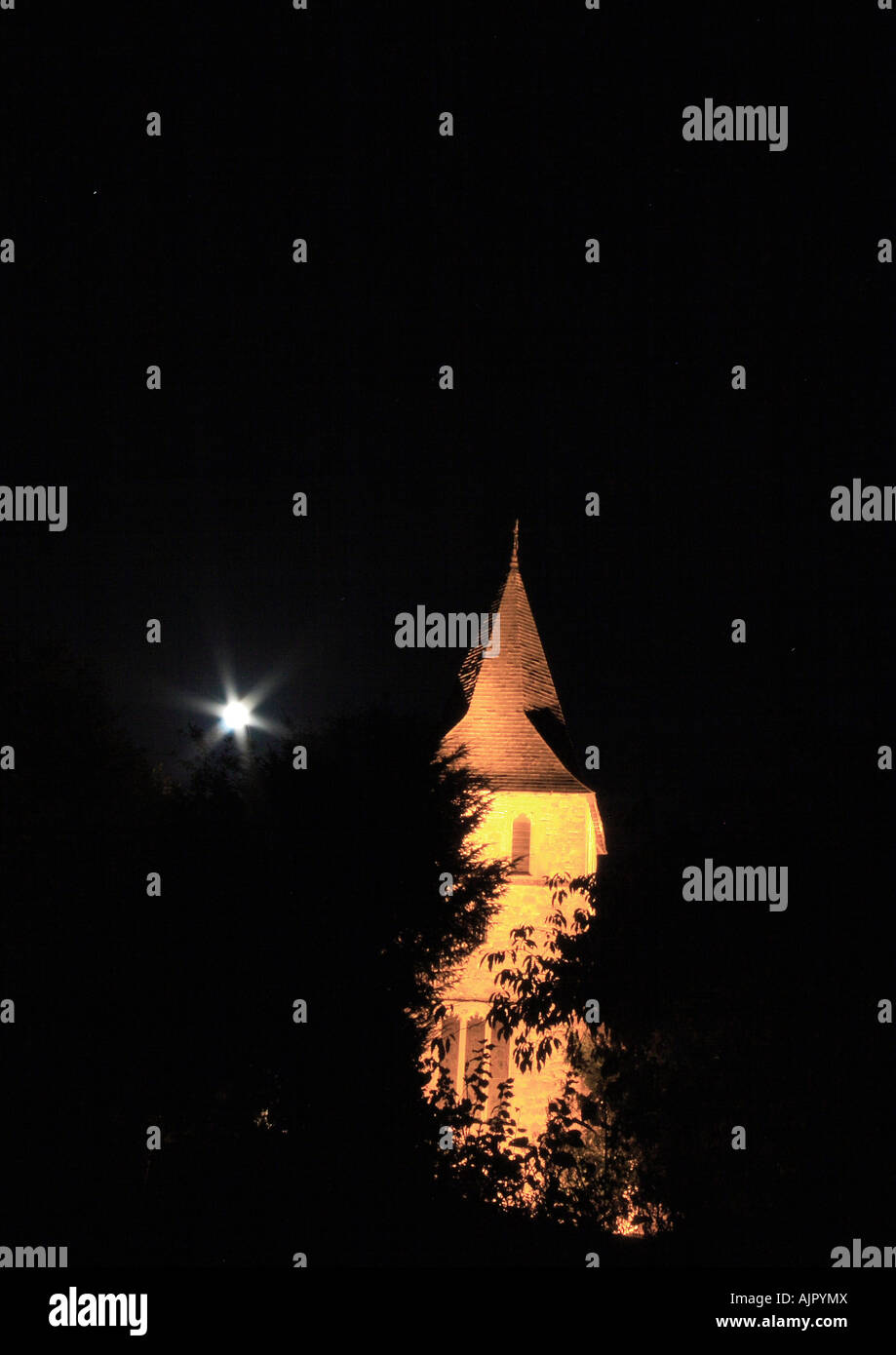 The Moon shines down on a spotlit church tower Stock Photo - Alamy
