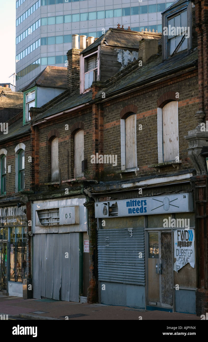 A row of run down shops in Croydon, Surrey with a new office block in ...