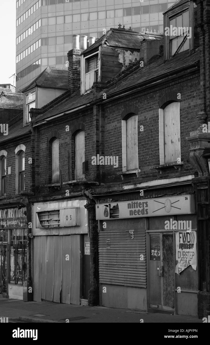 A row of run down shops in Croydon, Surrey with a new office block in ...