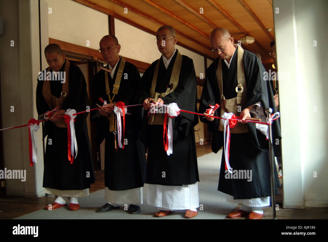 Priests cutting a ribbon at a ceremony Hyakumanben Temple Kyoto Japan ...
