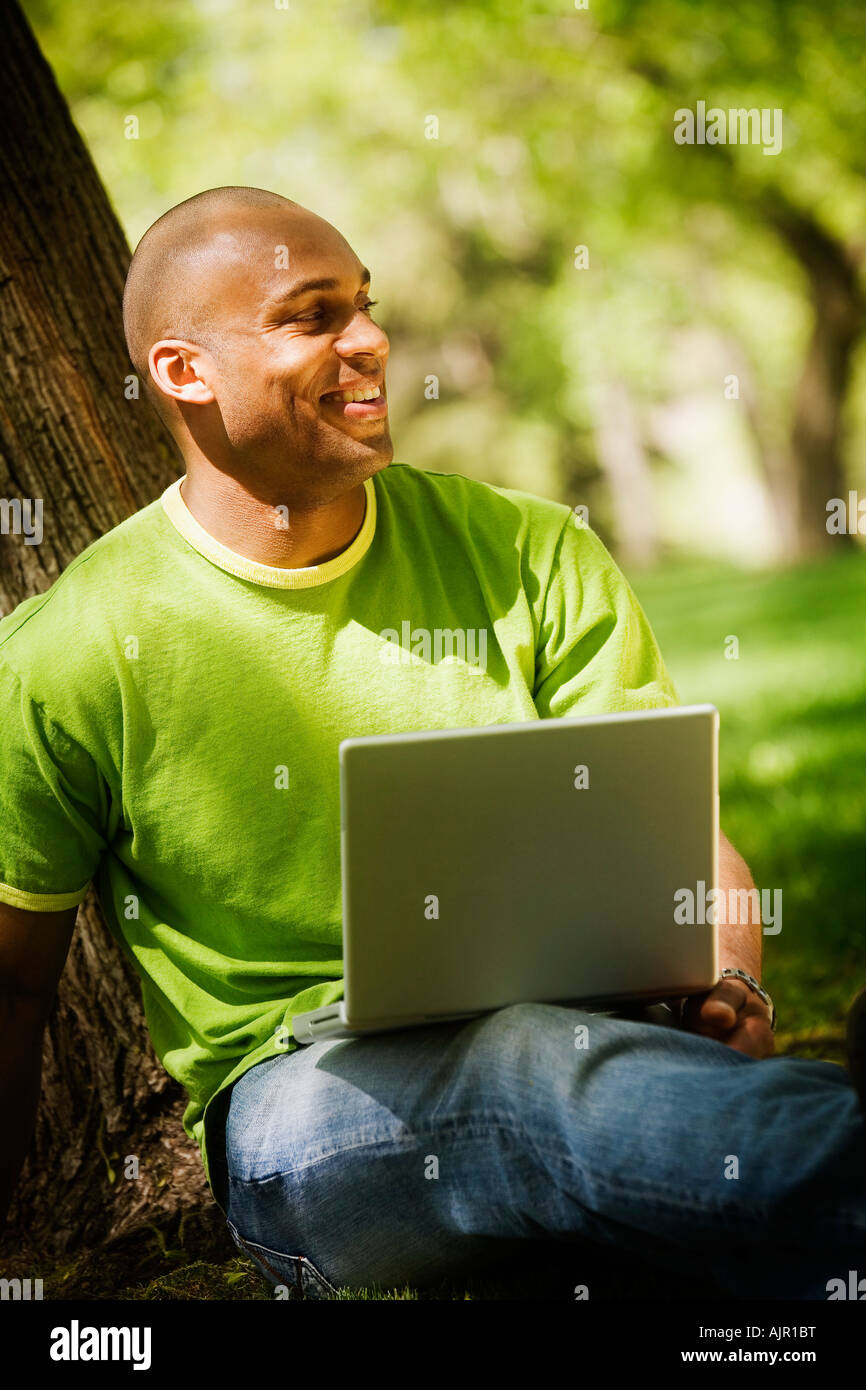 Man smiling and holding laptop computer Stock Photo - Alamy
