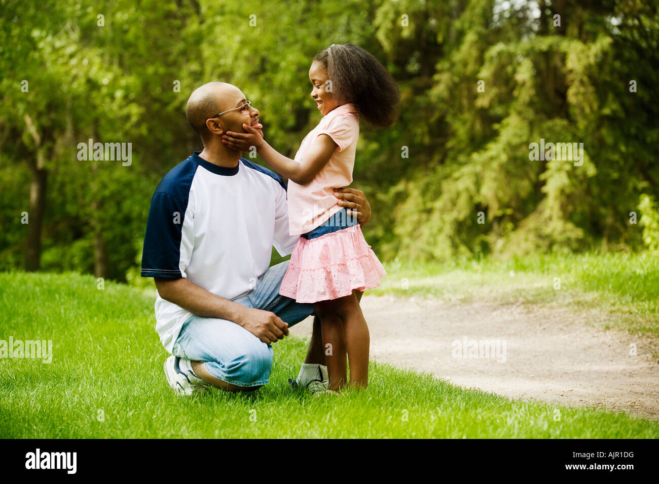 Side view of father with daughter in park Stock Photo - Alamy