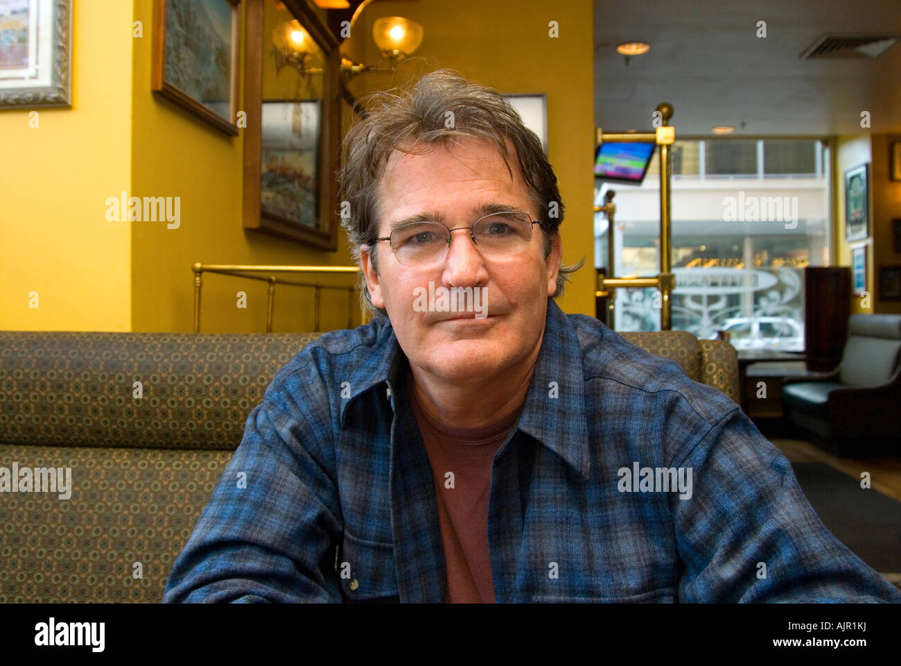 Portrait of man sitting in booth Stock Photo - Alamy