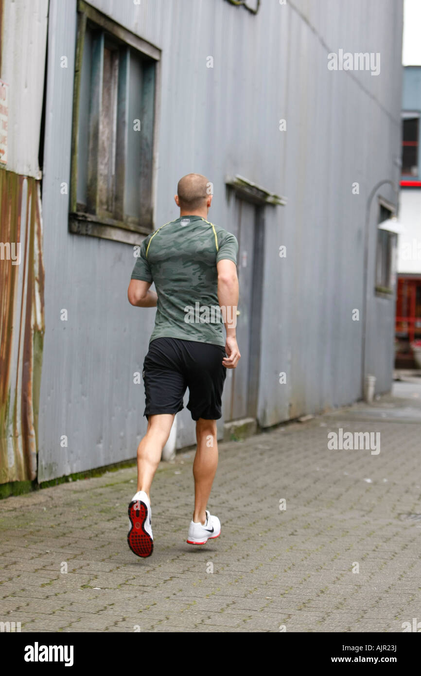 fit muscular hard body male running outdoors near a warehouse Stock ...