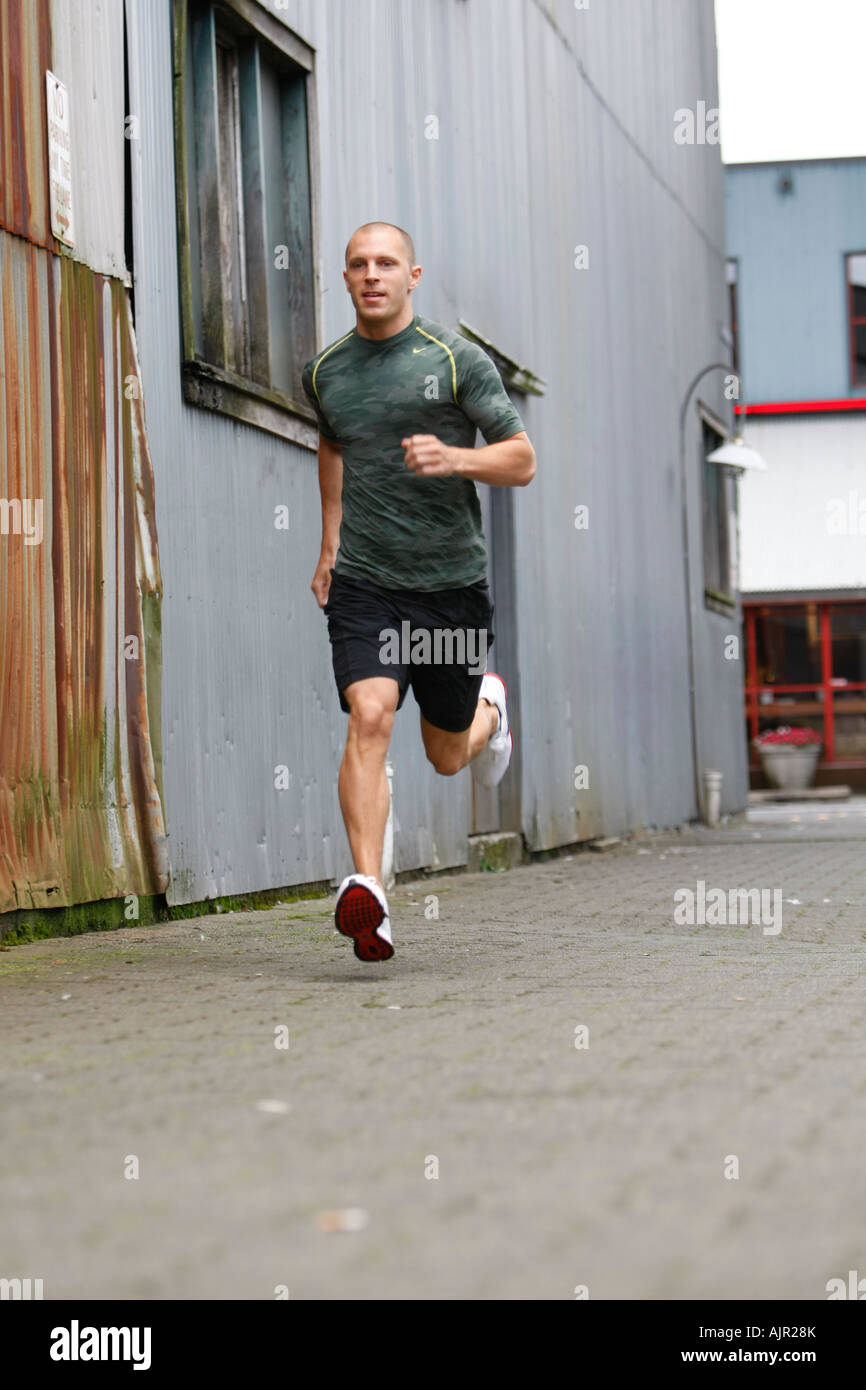 fit muscular hard body male running outdoors near a warehouse Stock ...