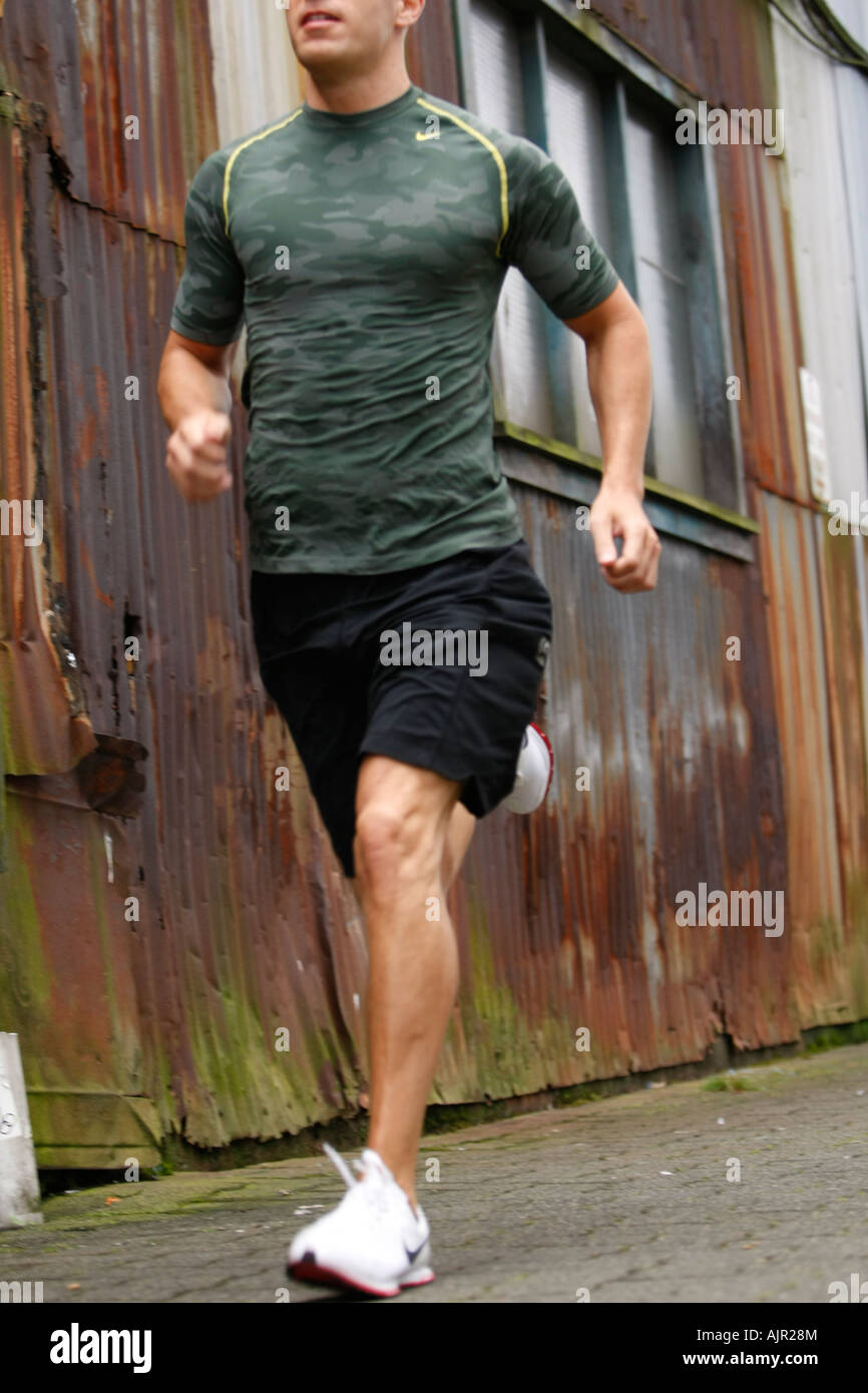 fit muscular hard body male running outdoors near a warehouse Stock ...