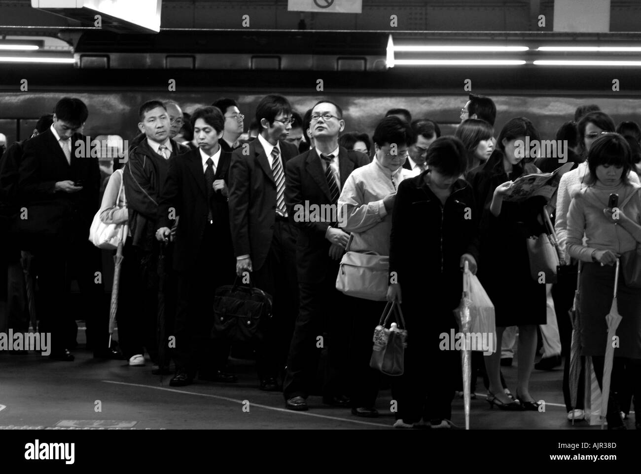 People waiting in a queue on a railway platform Osaka Japan Stock Photo ...
