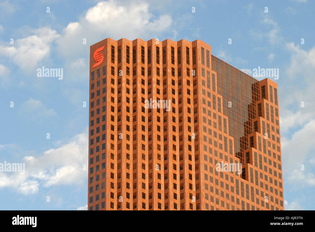brown jagged skyscraper against blue cloudy sky Stock Photo - Alamy