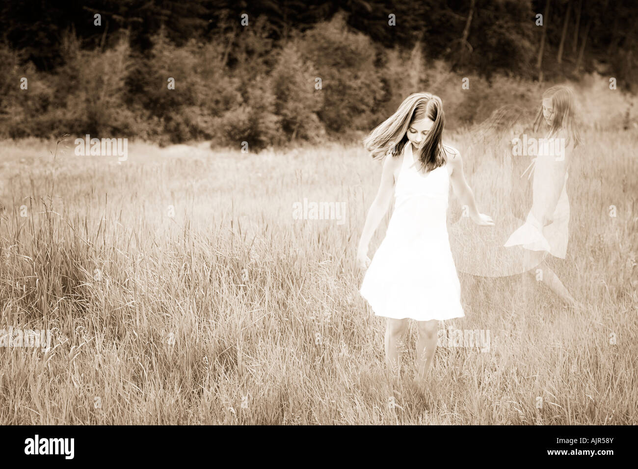 Girl playing in a field of grass Stock Photo - Alamy