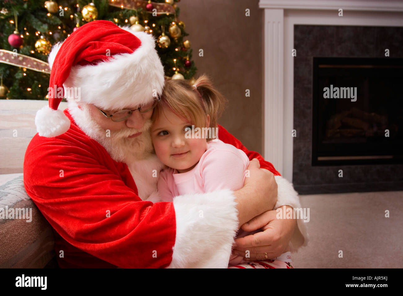 Santa Claus hugging a little girl Stock Photo - Alamy