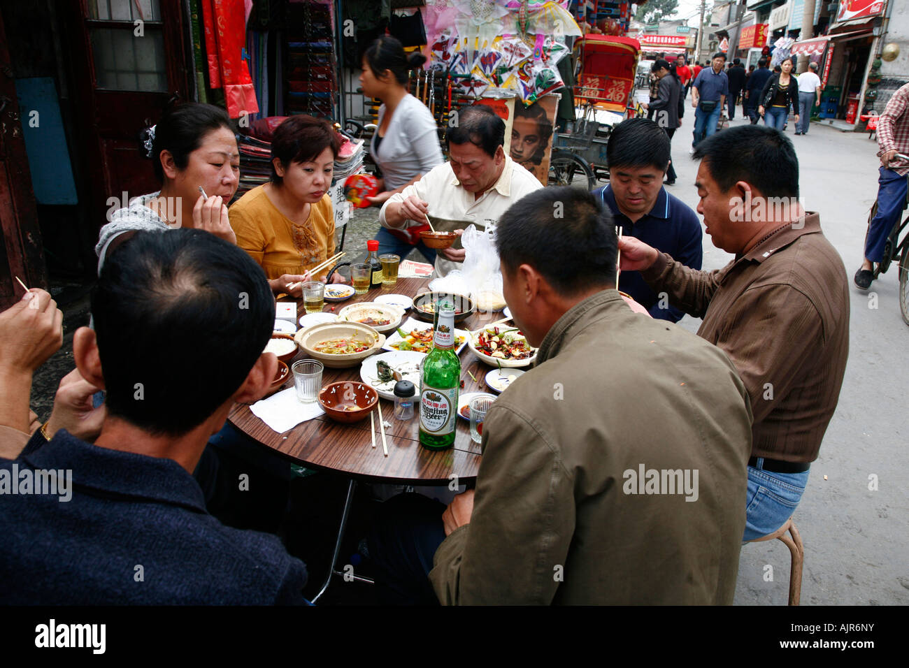 People eating at an outdoors restaurant on Dazhalan Jie street Beijing ...