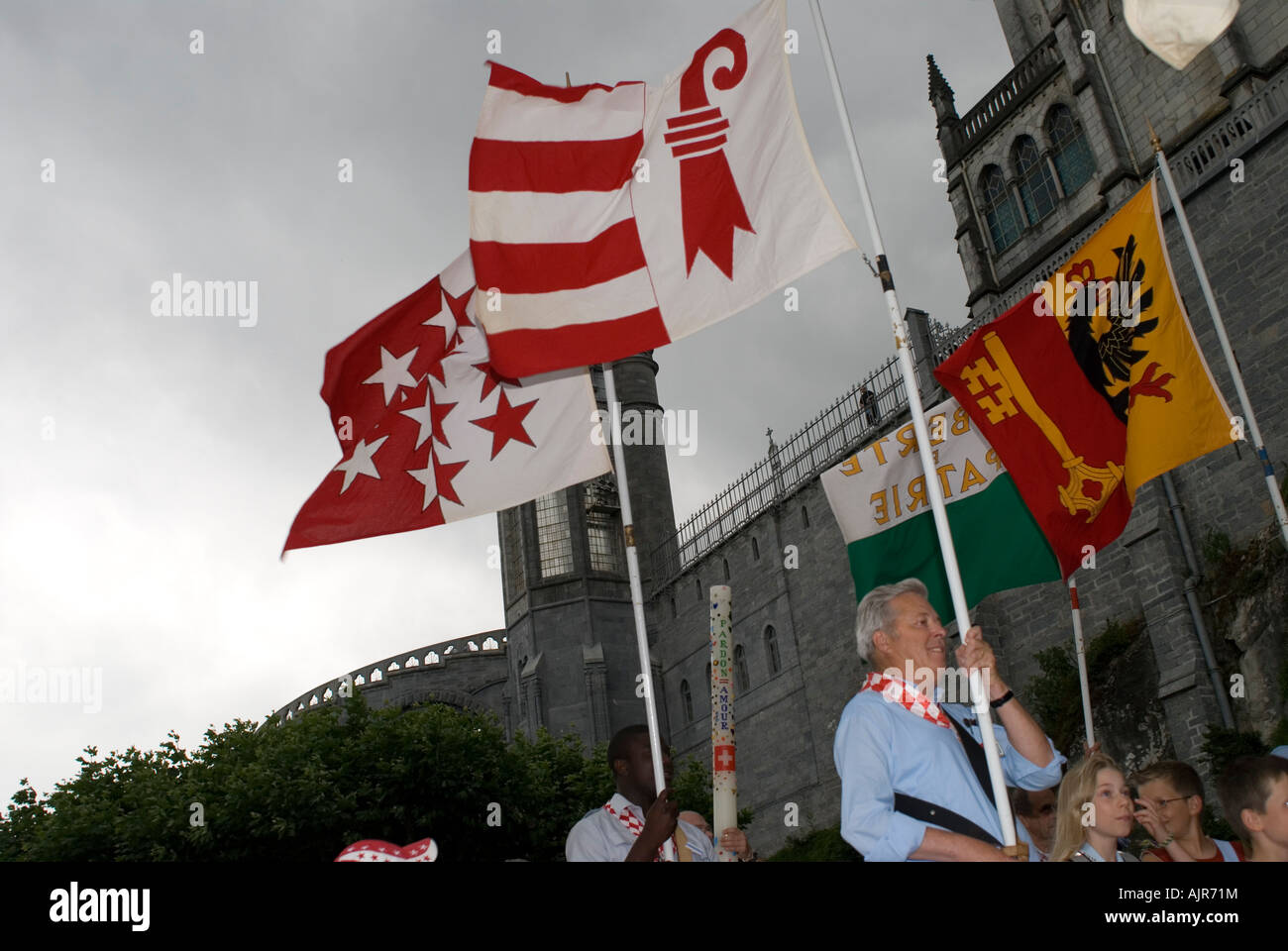 Pilgrims with flags near grotto Stock Photo - Alamy