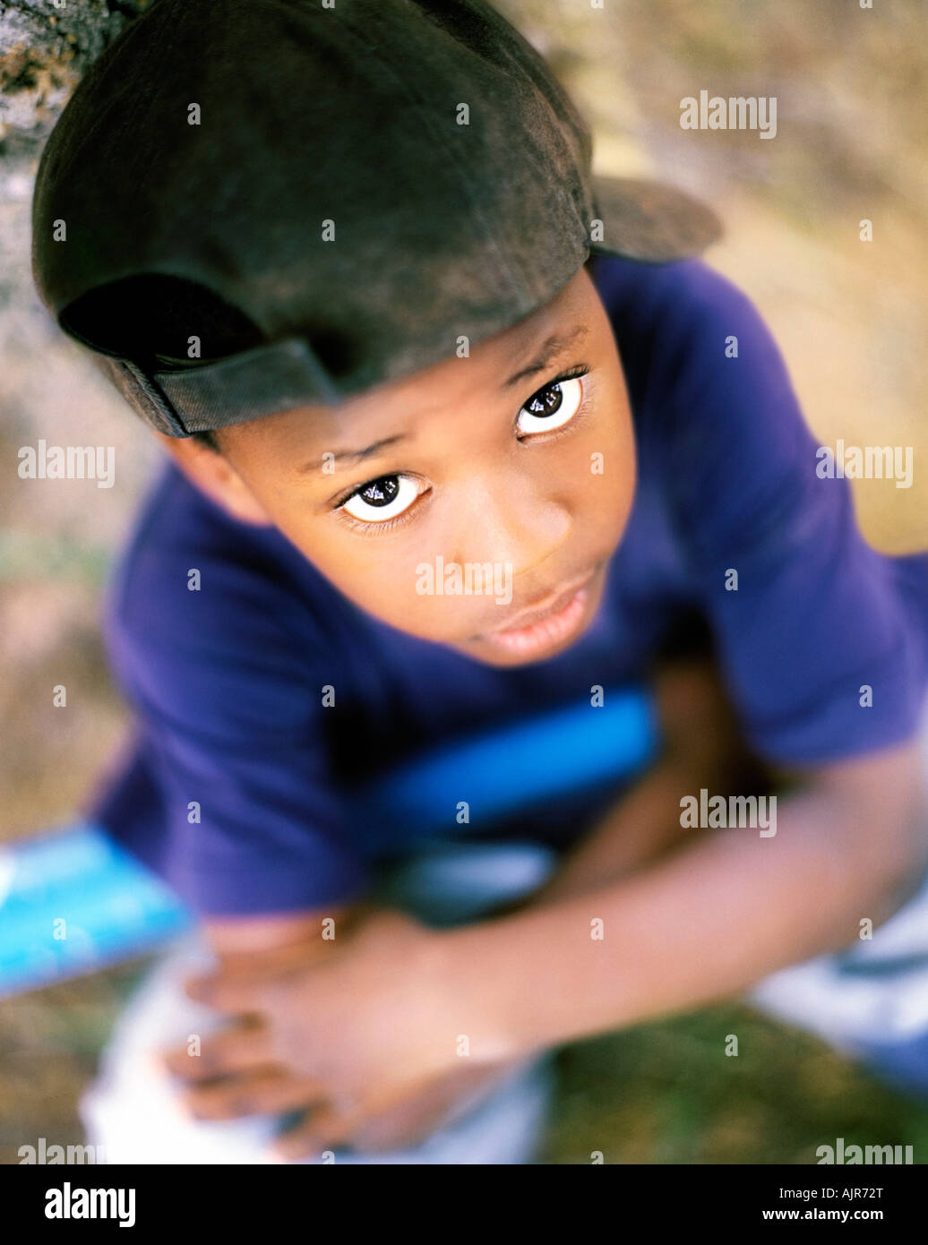 Boy with baseball cap looking up Stock Photo - Alamy