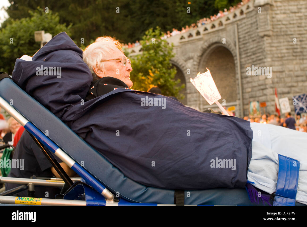 Pilgrim, sick in bed, with candle in front of Basilica of the ...