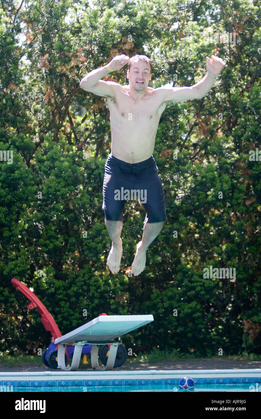 man jumping in pool doing a cannon ball in his bathing suit Stock Photo ...