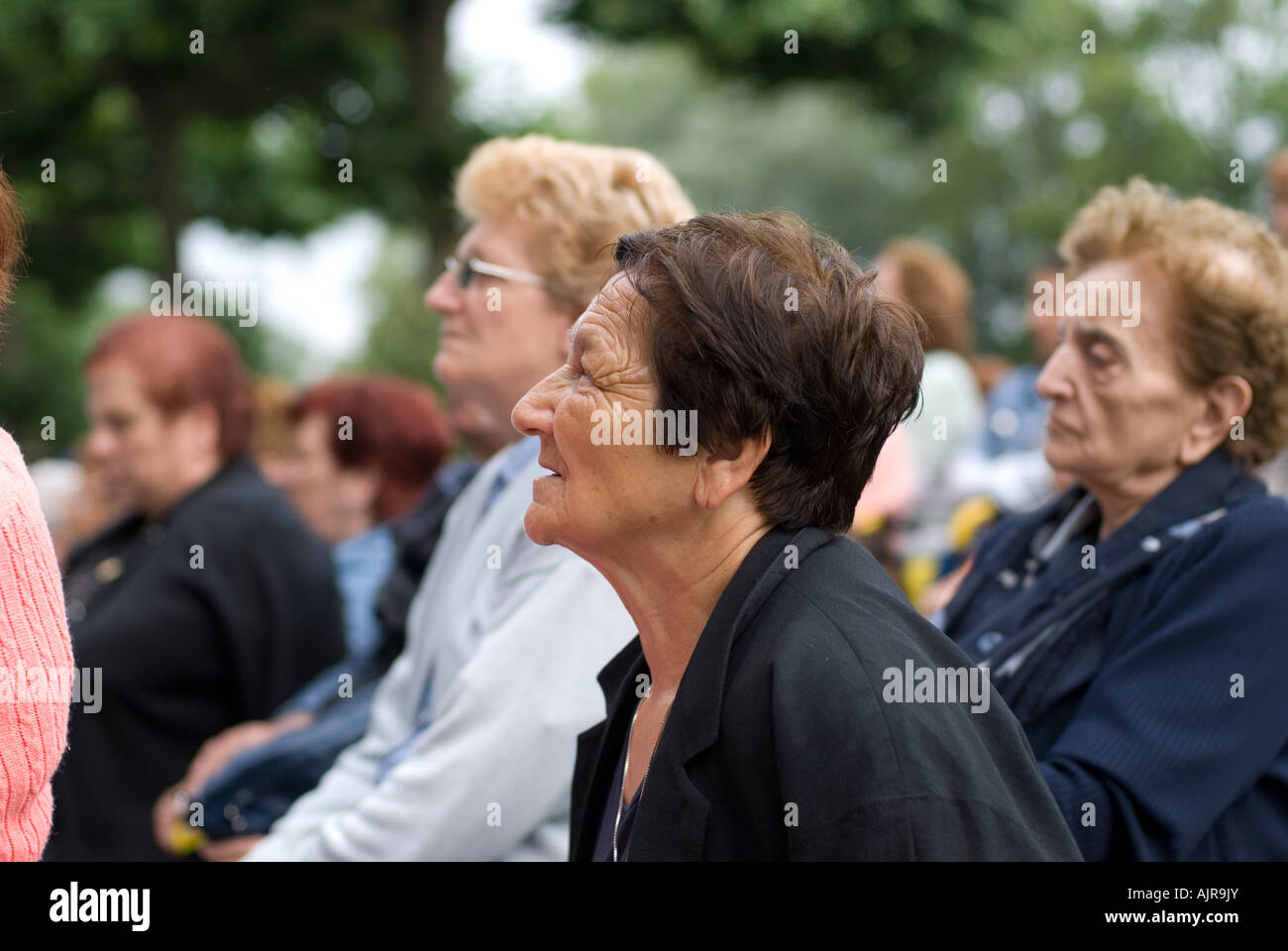 Pilgrims praying and getting blessings in front of grotto, Notre Dame ...