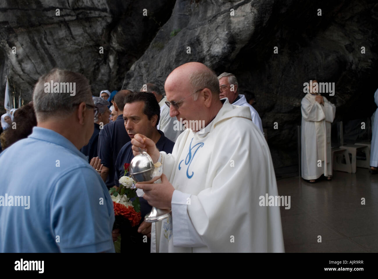 Blessings given by priest in front of Grotto Stock Photo - Alamy