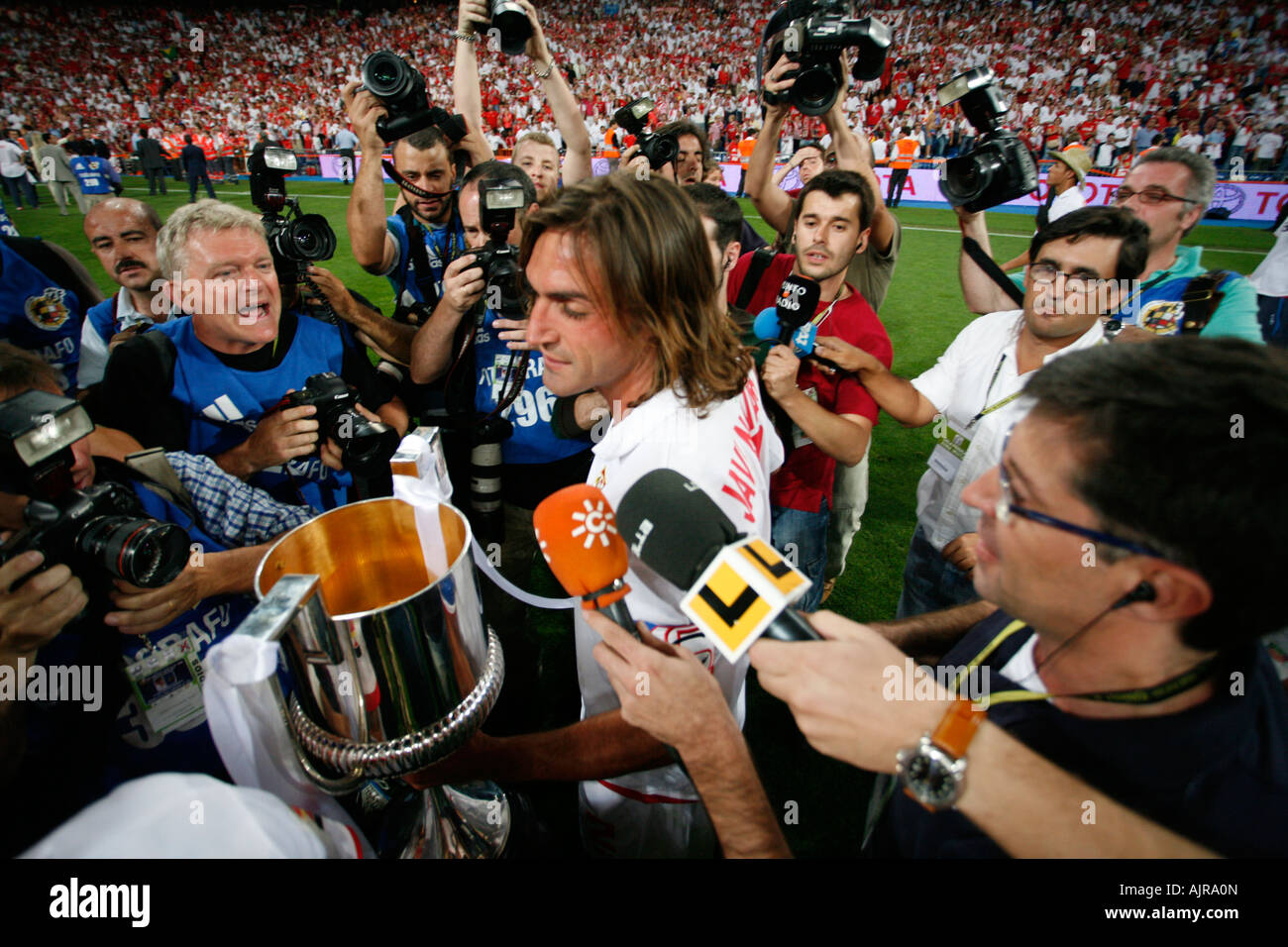 Javi Navarro with the Cup surronded by journalists on the field Stock ...