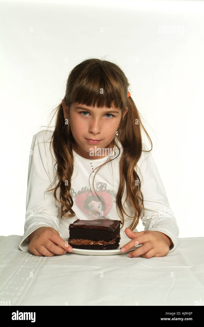 Brown haired Preteen girl sitting at a table over a piece of chocolate ...