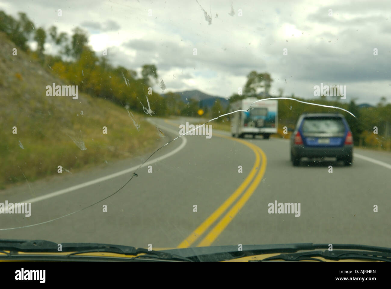 View through a cracked windshield covered with splattered dead bugs ...