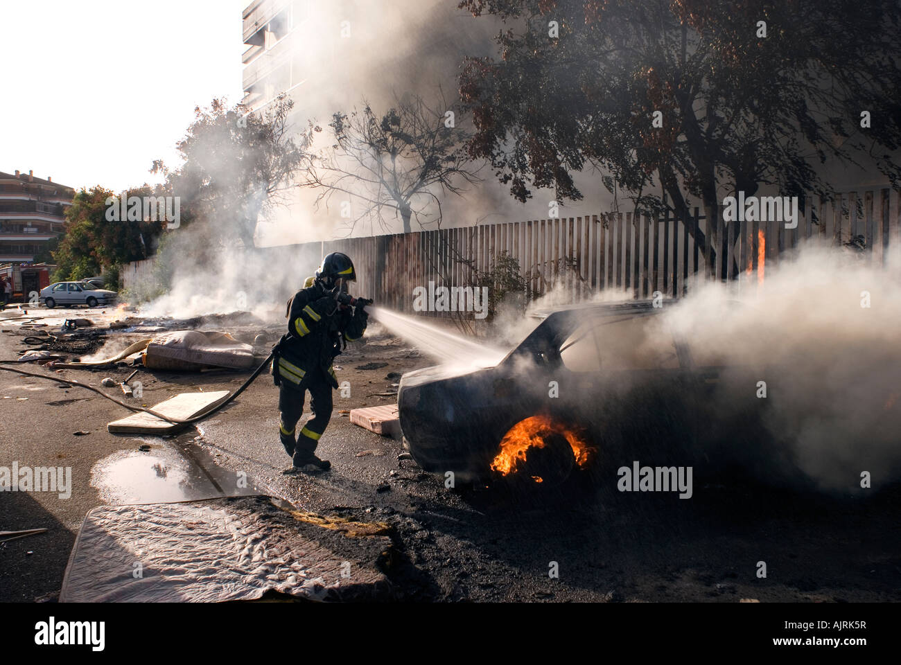 fireman action extinguishing a car fire Stock Photo - Alamy