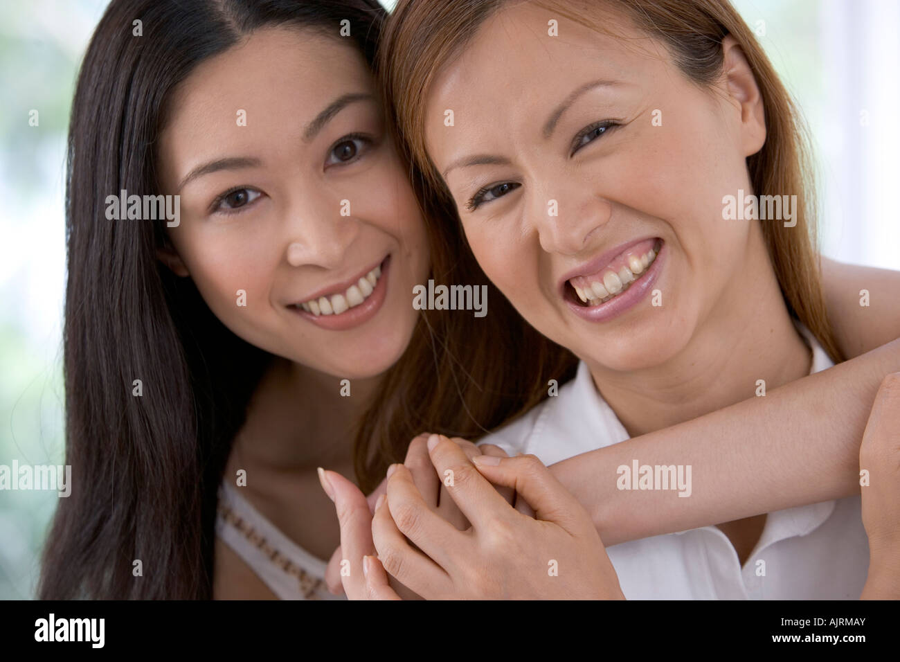 Portrait of a young woman hugging another young woman from behind Stock ...