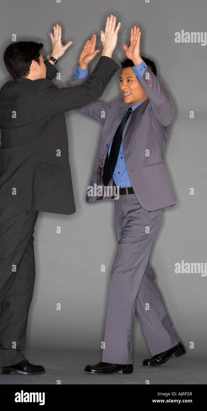 Two businessmen giving high five Stock Photo - Alamy