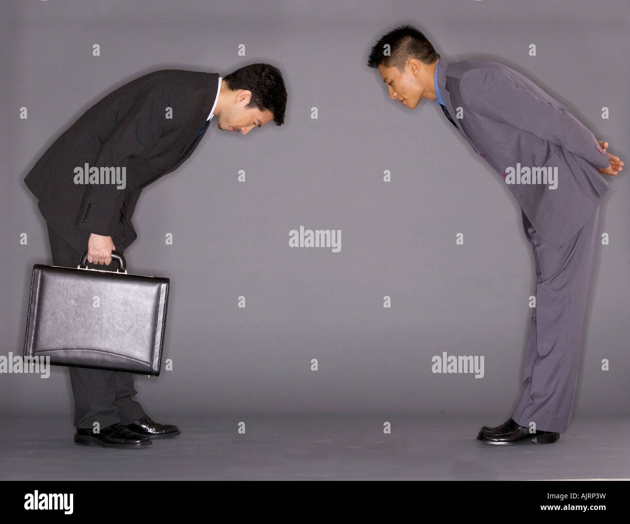 Side profile of two businessmen bowing Stock Photo - Alamy