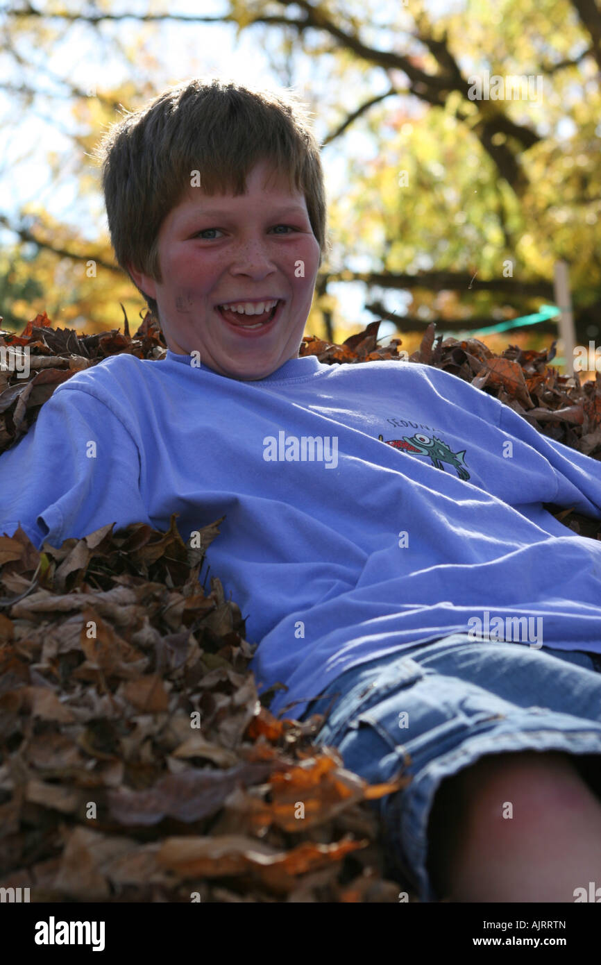 boy playing in leaves in fall Stock Photo - Alamy