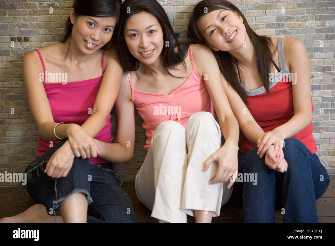 Portrait of three young women sitting together Stock Photo - Alamy