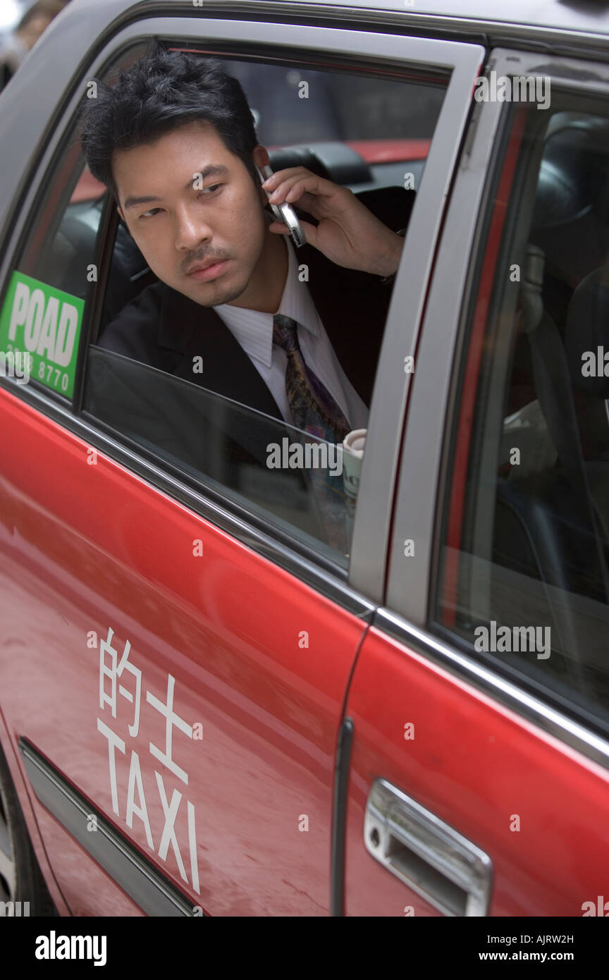 Businessman on cell phone in cab Stock Photo - Alamy