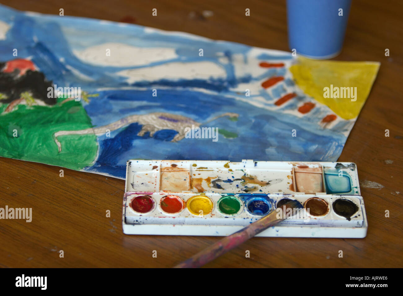 A primary school student's painting with a watercolor set and brush on ...