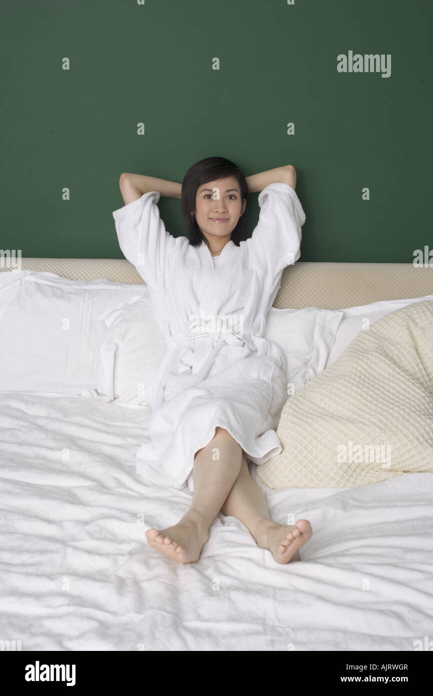 Portrait of a young woman reclining on a bed Stock Photo - Alamy